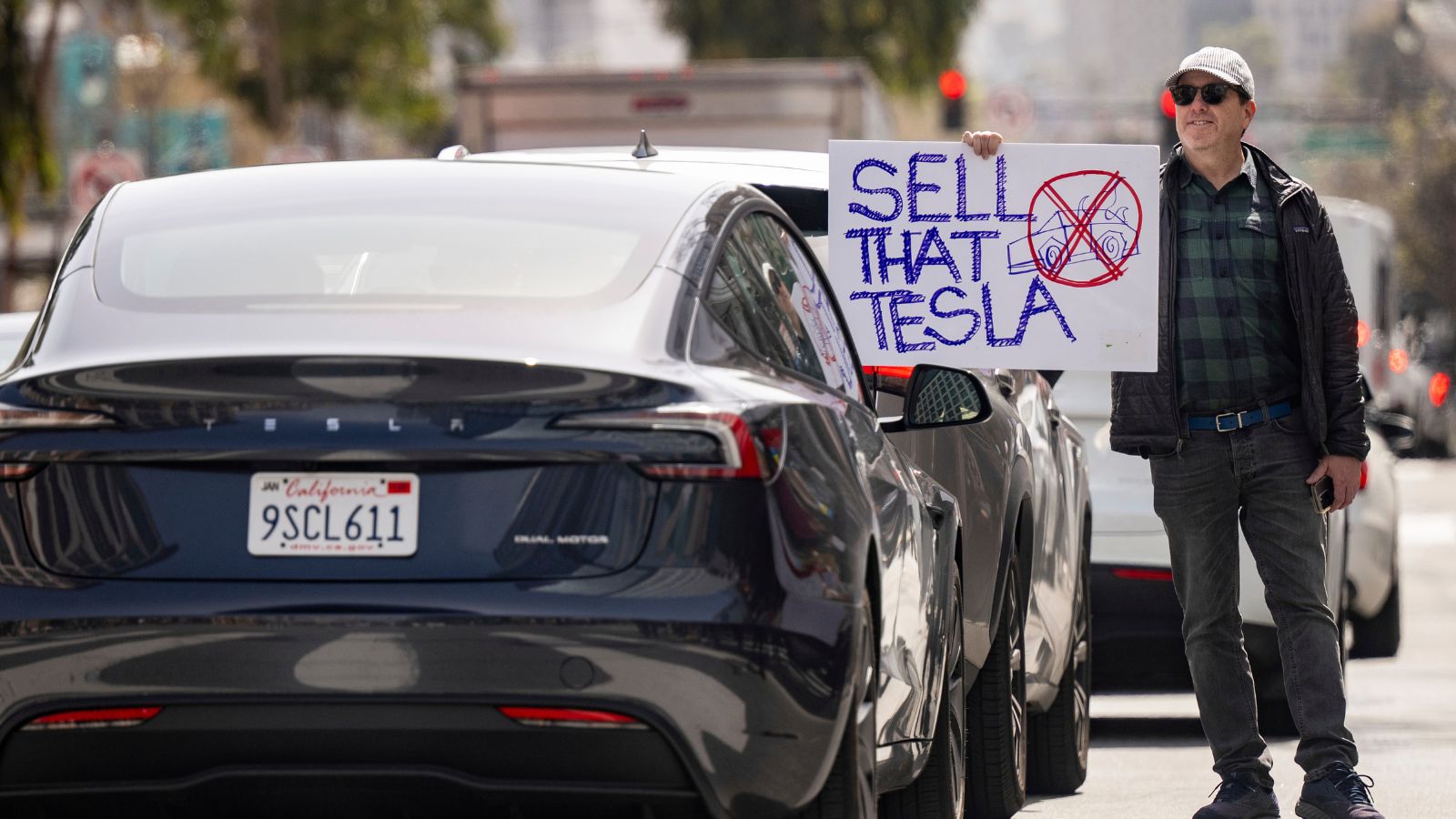 In pictures: Hundreds protest outside Tesla showrooms over Musk’s role ...